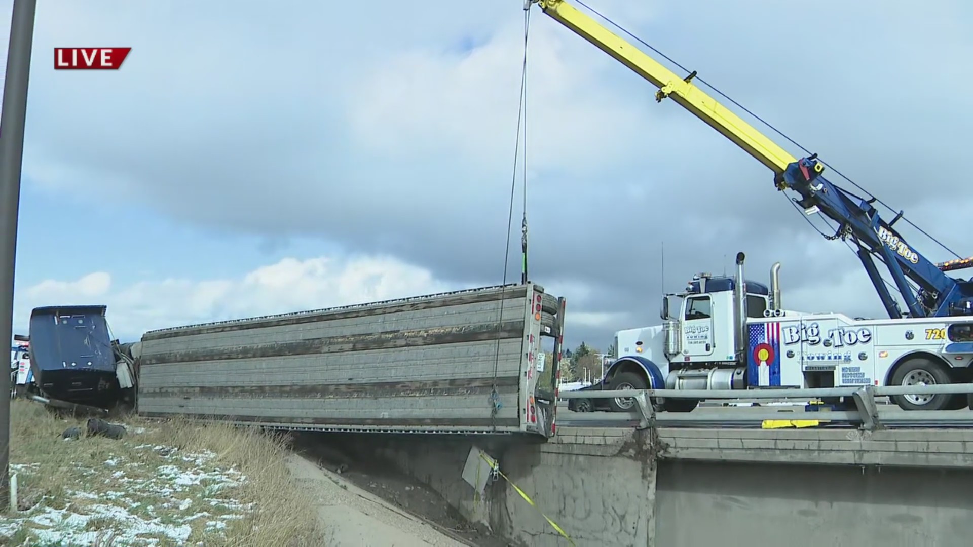 Crews working to lift crashed semi-trailer dangling on I-70 overpass ...